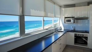 Cozinha com vista para o oceano, micro-ondas e forno.