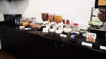 Um balcão de buffet com diversos alimentos e recipientes.
