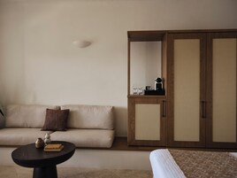 Uma sala de estar minimalista com um sofá, uma mesa de centro e um guarda-roupa.