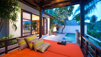 Uma área de estar ao ar livre aconchegante com piscina, cercada por vegetação exuberante e uma vista ampla do céu.