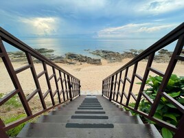 Uma praia privada, guarda-sóis de praia, toalhas de praia, caiaque 