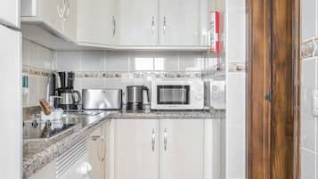 Um frigorífico, um micro-ondas, um forno, uma placa de cozinha