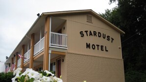 Um edifício de dois andares com uma placa que diz 'STARDUST MOTEL'.