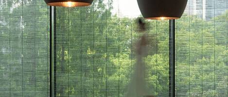 Um interior moderno com uma janela ampla, piscina e iluminação pendente.
