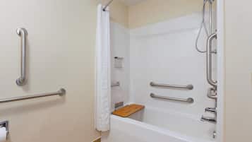 Casa de banho com chuveiro, barras de apoio, porta-toalhas e suporte para papel higiénico.