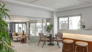 Cozinha espaçosa e moderna, com bancada de mármore e área de balcão com banquetas.