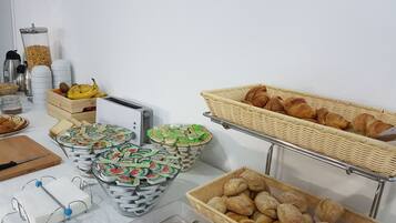 Um buffet de café da manhã com diversos alimentos e utensílios.