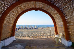 Uma praia privada, espreguiçadeiras, guarda-sóis de praia 