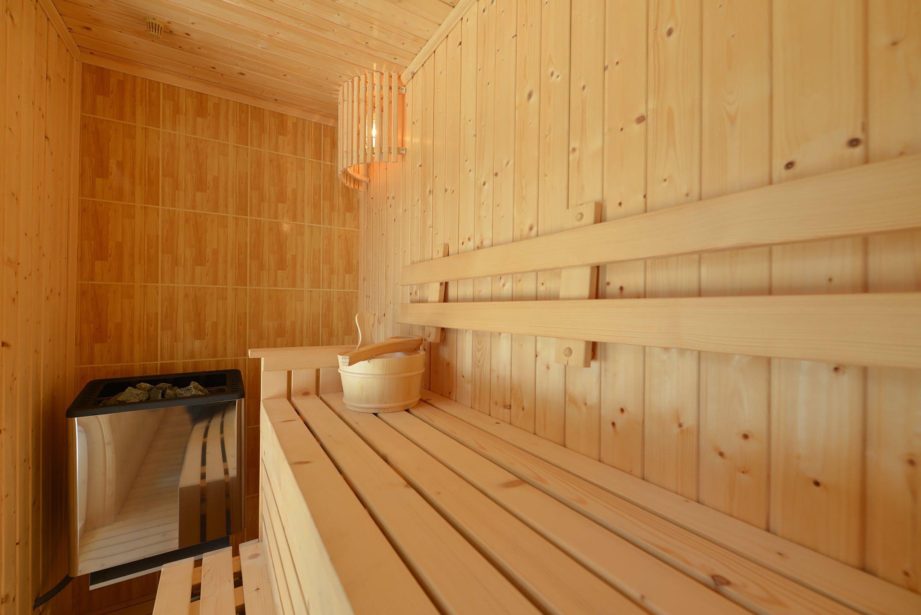 Uma sala de sauna com paredes e bancos de madeira.