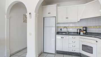 Um frigorífico/congelador grande, um micro-ondas, uma placa de cozinha