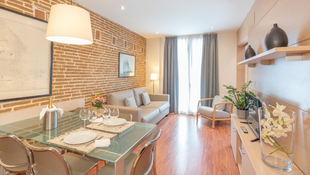 Uma sala de estar moderna com uma mesa de jantar de vidro, um sofá e uma mesa de centro.