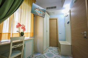 Quarto com escrivaninha, cadeira, guarda-roupa, cama e janela com cortinas.