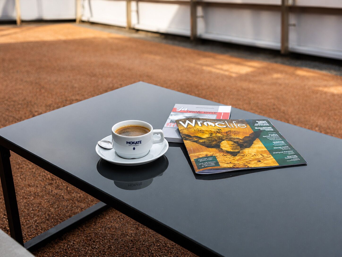 Uma mesa com uma xícara de café e uma revista.