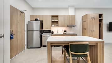 Um frigorífico/congelador grande, um micro-ondas, uma placa de cozinha