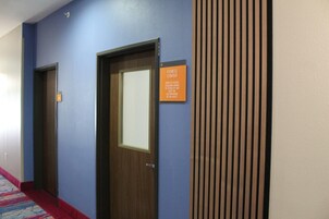 Um corredor com duas portas, uma delas com uma placa indicando um centro de atividades físicas.