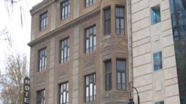 Um edifício de vários andares com um letreiro grande que diz 'HOTEL' na fachada.