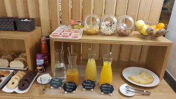 Buffet de café da manhã com diversos alimentos e bebidas.