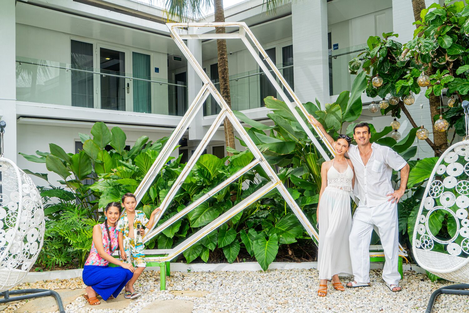 Um edifício moderno com estrutura de vidro geométrica, vegetação exuberante e esquema de cores branco e verde.