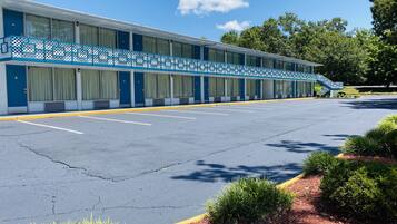 Um motel com fachada azul, várias divisões e uma galeria coberta.