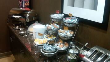 Buffet com diversos alimentos e uma torradeira.