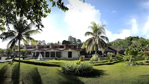 Um resort com piscina, palmeiras e um coreto.