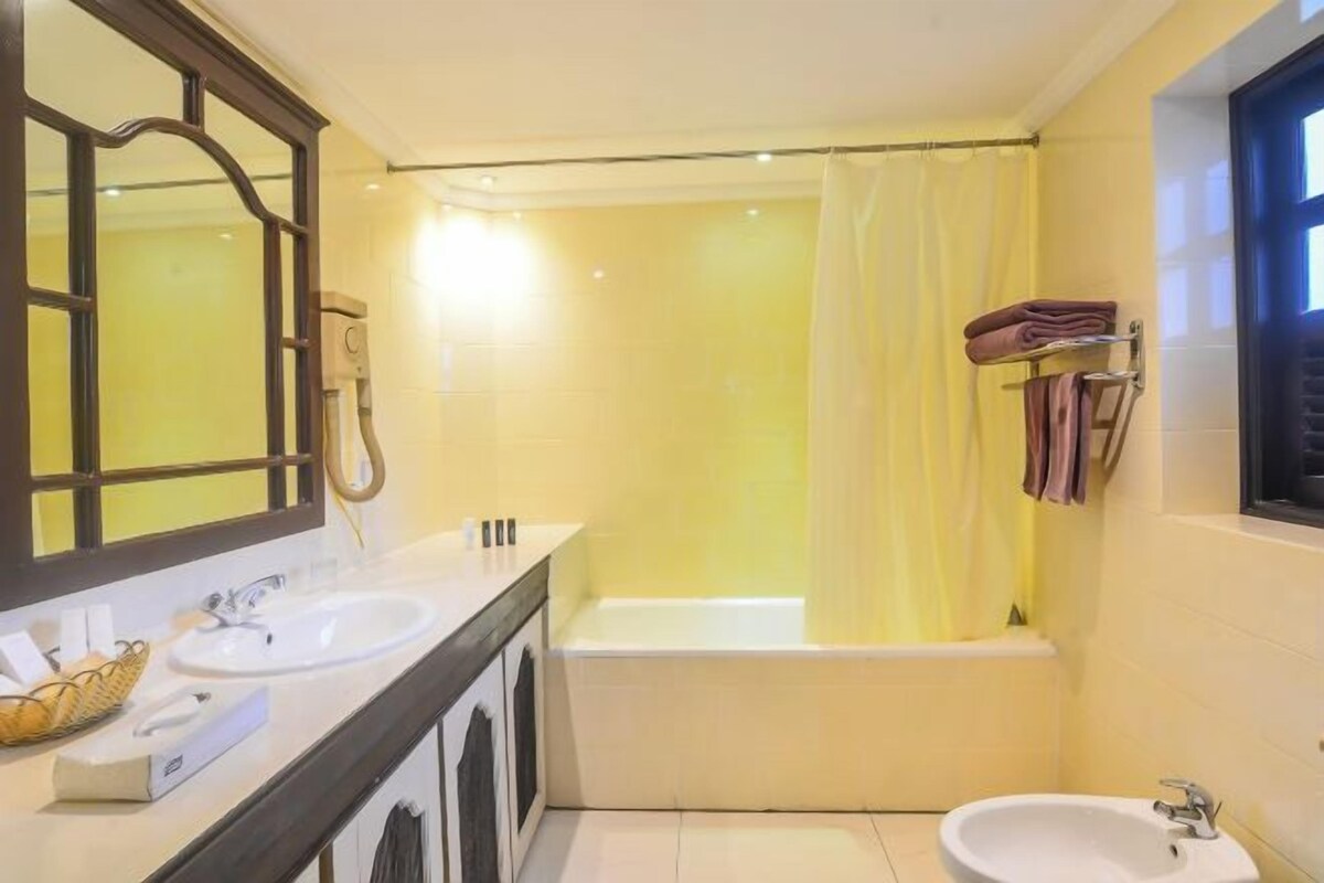 Uma casa de banho com banheira, lavatório e espelho.