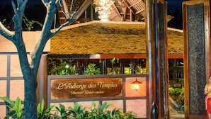 Um edifício com uma placa que diz "L'Auberge des Temples Cozinha Khmer Antiga".