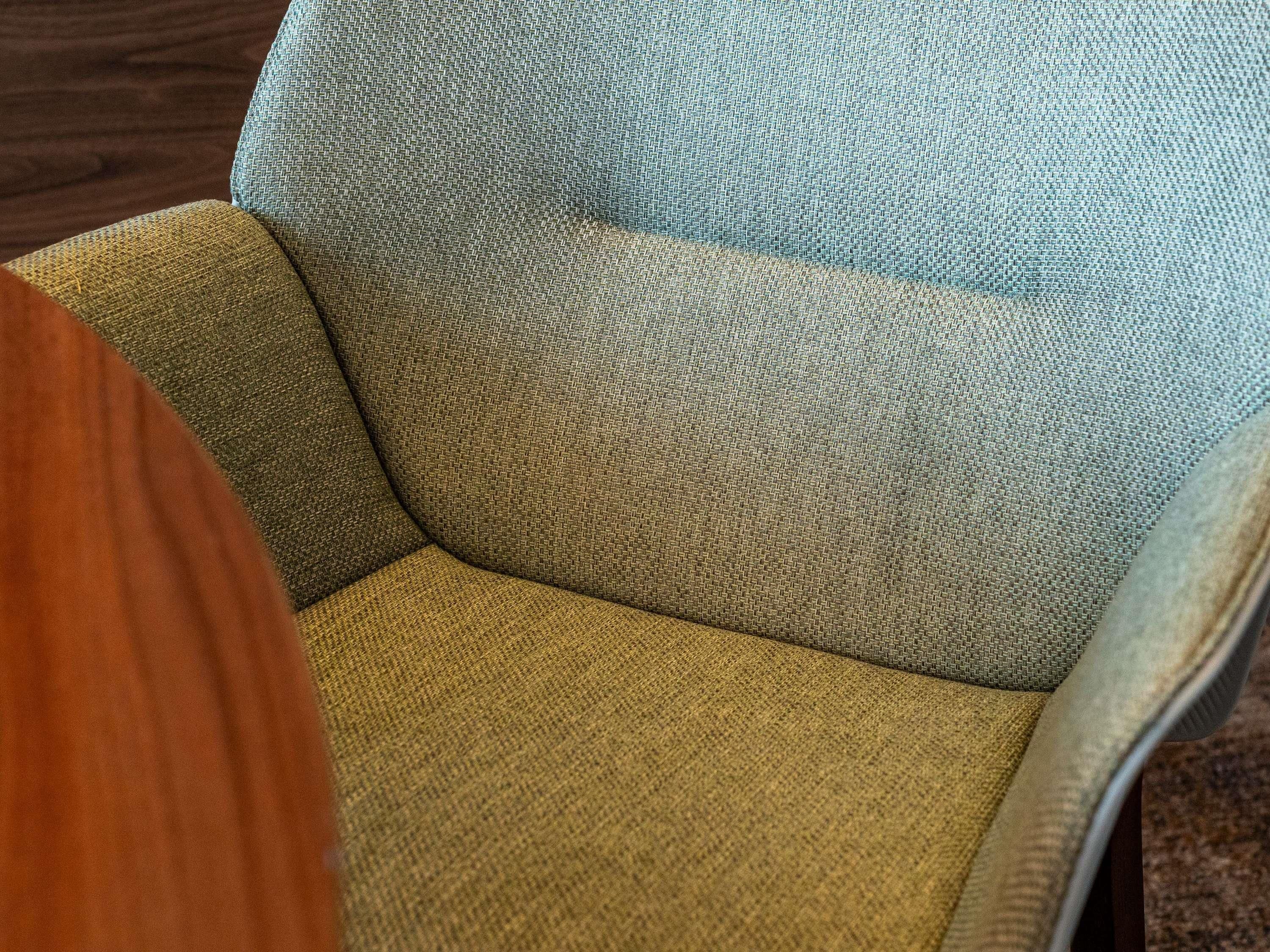 Um close-up de uma cadeira com tecido texturizado em tons de azul e amarelo.