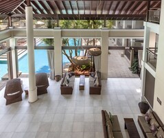 Amplo espaço interno com vista para a piscina, apresentando várias áreas de estar e um lustre.
