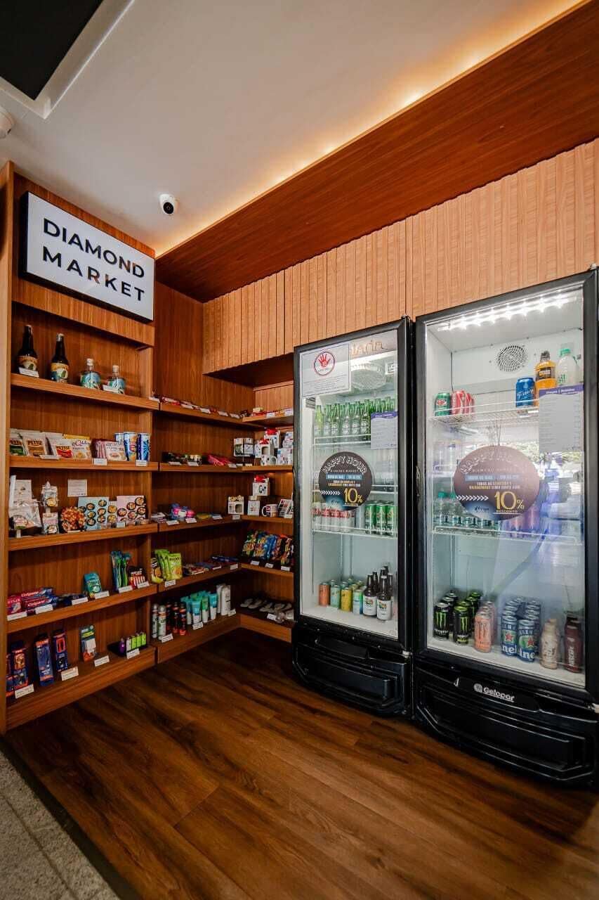Loja com prateleiras de madeira e dois refrigeradores cheios de bebidas.