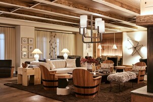 Uma sala de estar moderna com móveis de madeira, lareira e um candelabro.