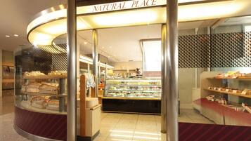Uma padaria com uma vitrine repleta de doces e um letreiro com a inscrição "NATURAL PLACE".