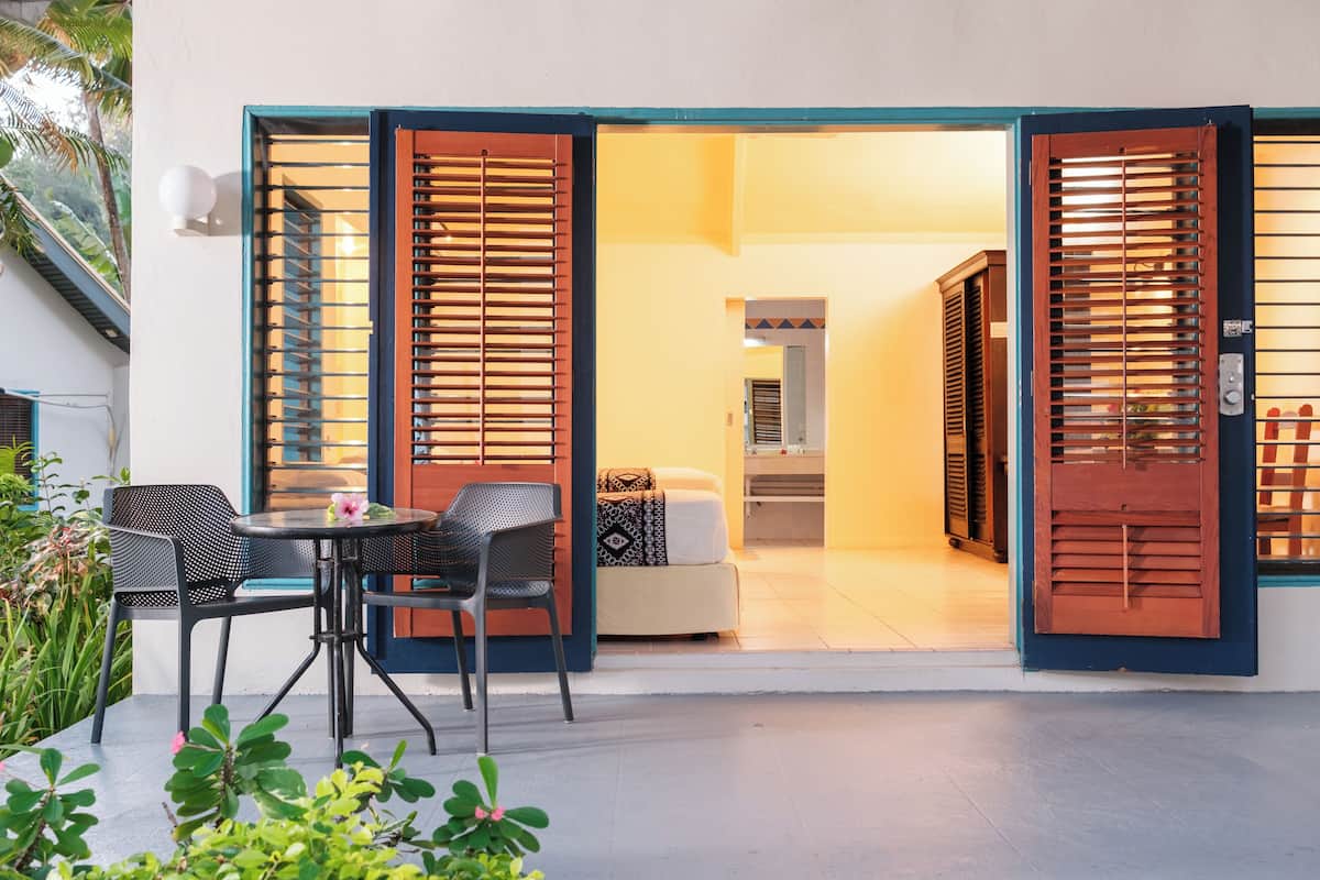 Uma porta aberta que dá para um quarto com um sofá e uma mesa pequena.