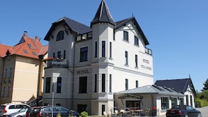 Um hotel com uma torre imponente, várias janelas e uma varanda.