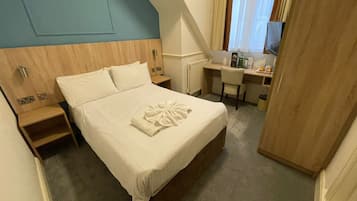 Um quarto com uma cama, uma escrivaninha e uma cadeira.