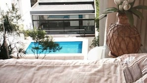 Quarto com vista para uma piscina e um edifício moderno.