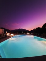 Piscina ao entardecer com céu roxo.