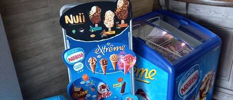 Máquina de venda automática de sorvetes Nestlé e um expositor com diversos sabores de sorvete.