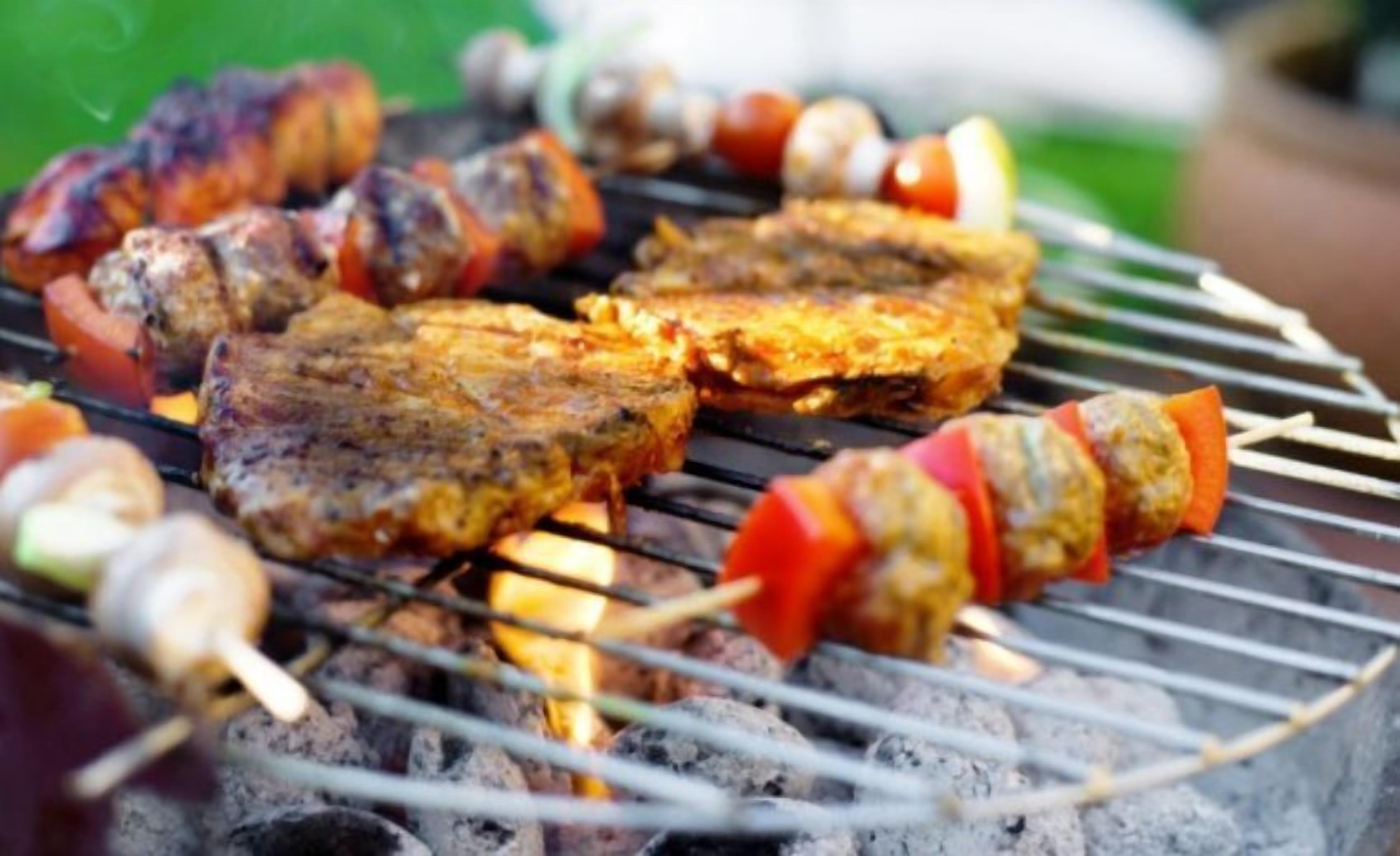 Espetinhos de carne grelhada e legumes na churrasqueira.