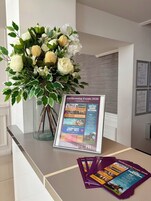 Bancada de recepção com arranjo floral e folheto de eventos futuros no The Park Hotel Liverpool.