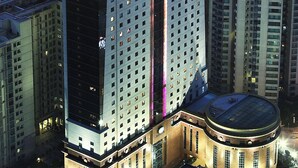 Um edifício alto com telhado em estilo tradicional de pagode, cercado por edifícios modernos e imponentes.