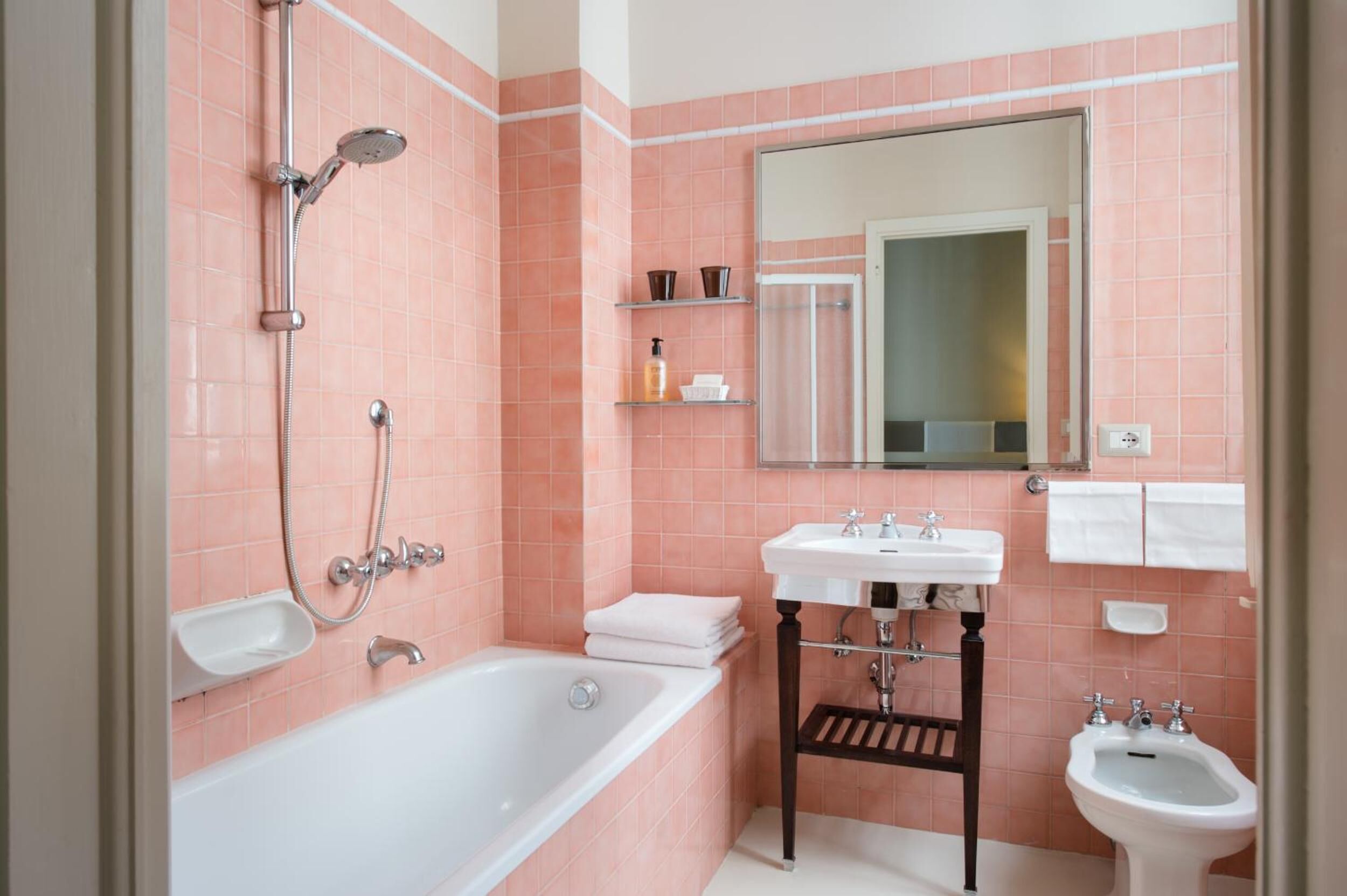 Um banheiro com banheira, pia, bidê e chuveiro.