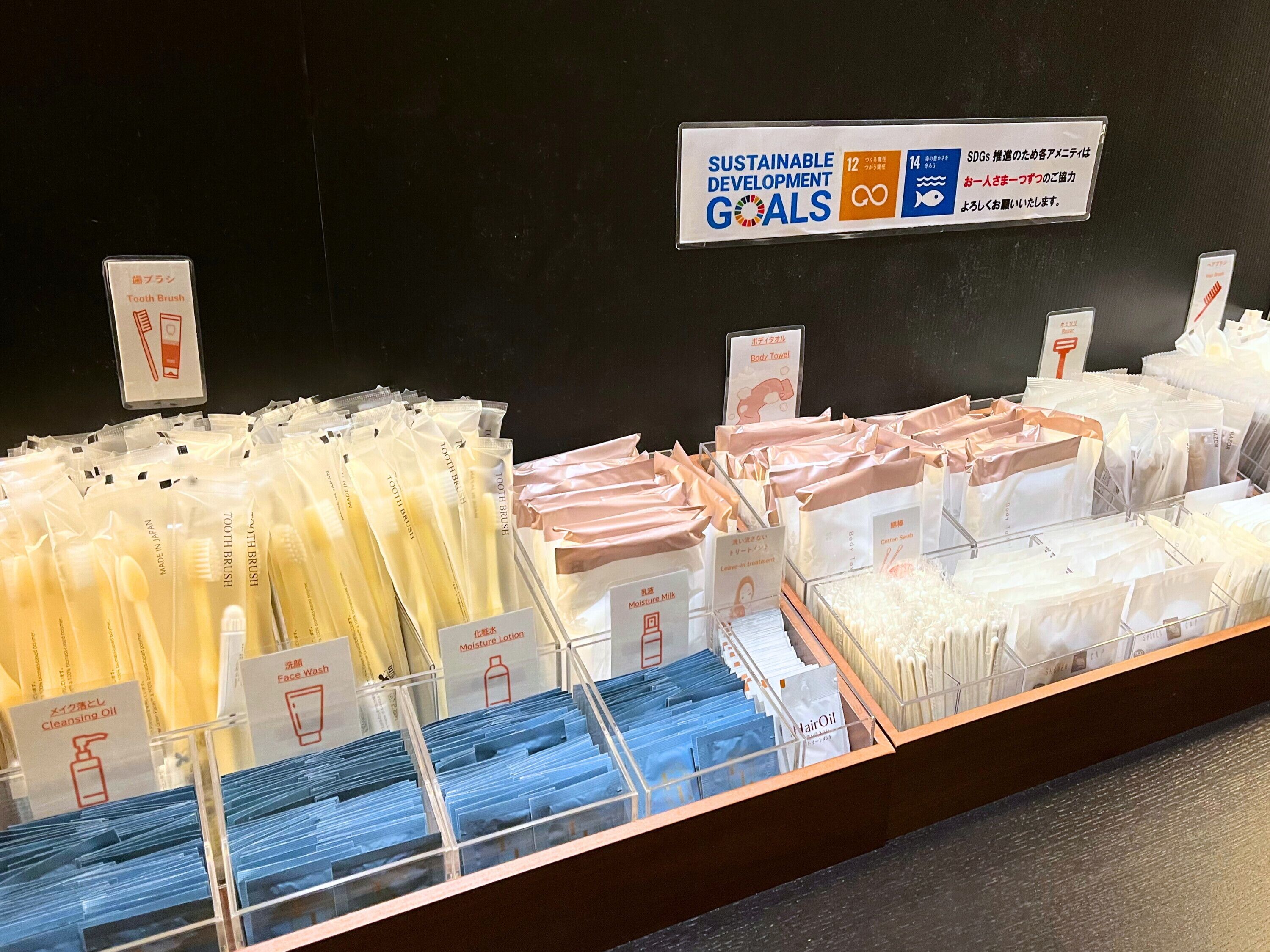 Exposição de produtos de higiene pessoal, incluindo escovas de dentes, toalhas de banho e diversos artigos de toilette.