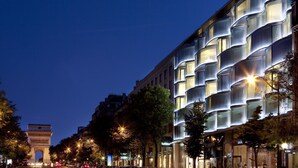 Um edifício moderno com fachada singular, destacando uma série de painéis iluminados.
