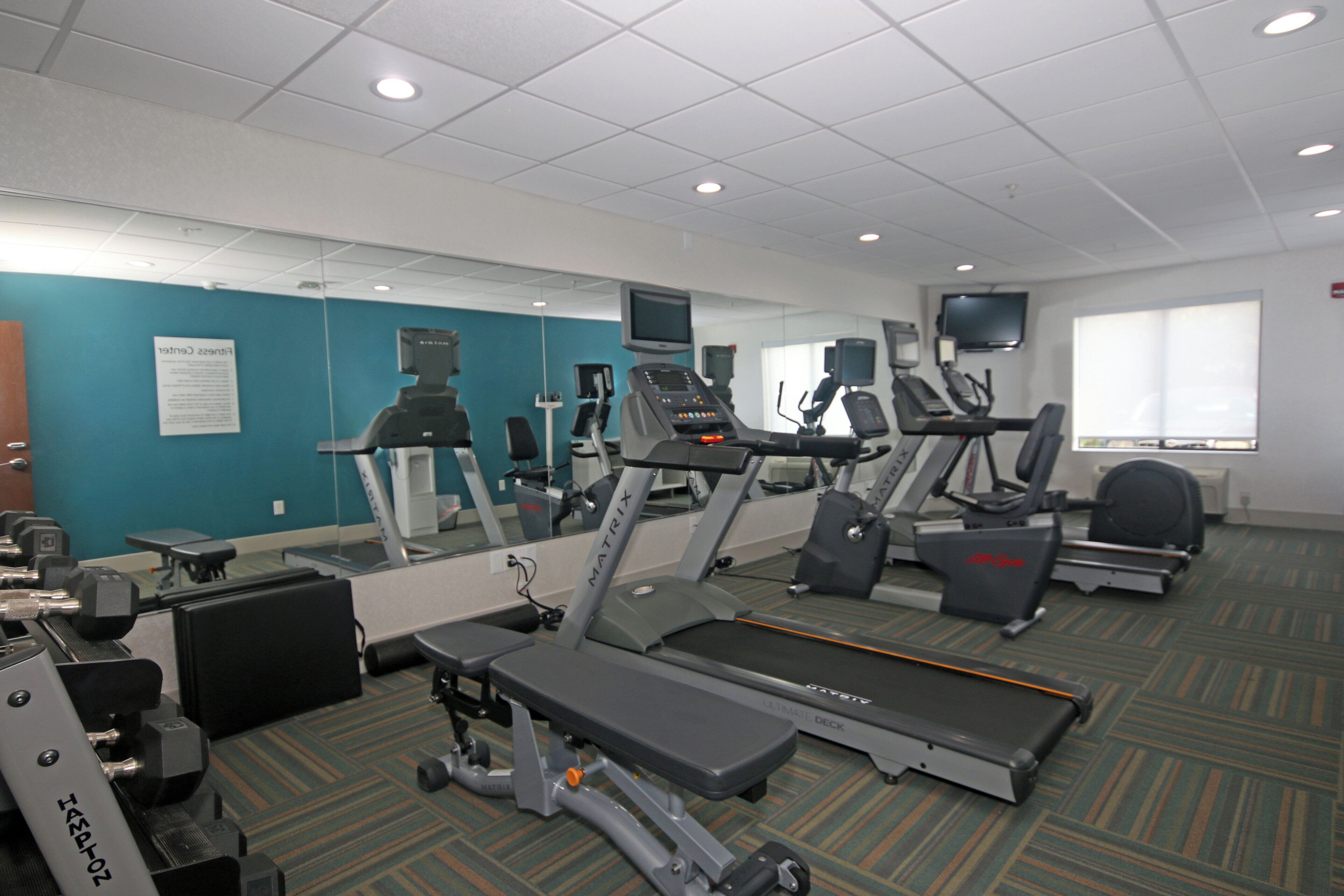 Academia com esteiras, elípticos e equipamentos de musculação.