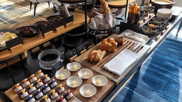 Uma mesa de buffet com diversos alimentos e acompanhamentos.
