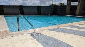 Uma piscina com uma placa indicando 'NÃO MERGULHAR'.