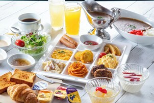 Uma bandeja de café da manhã com diversos alimentos, bebidas e acompanhamentos.