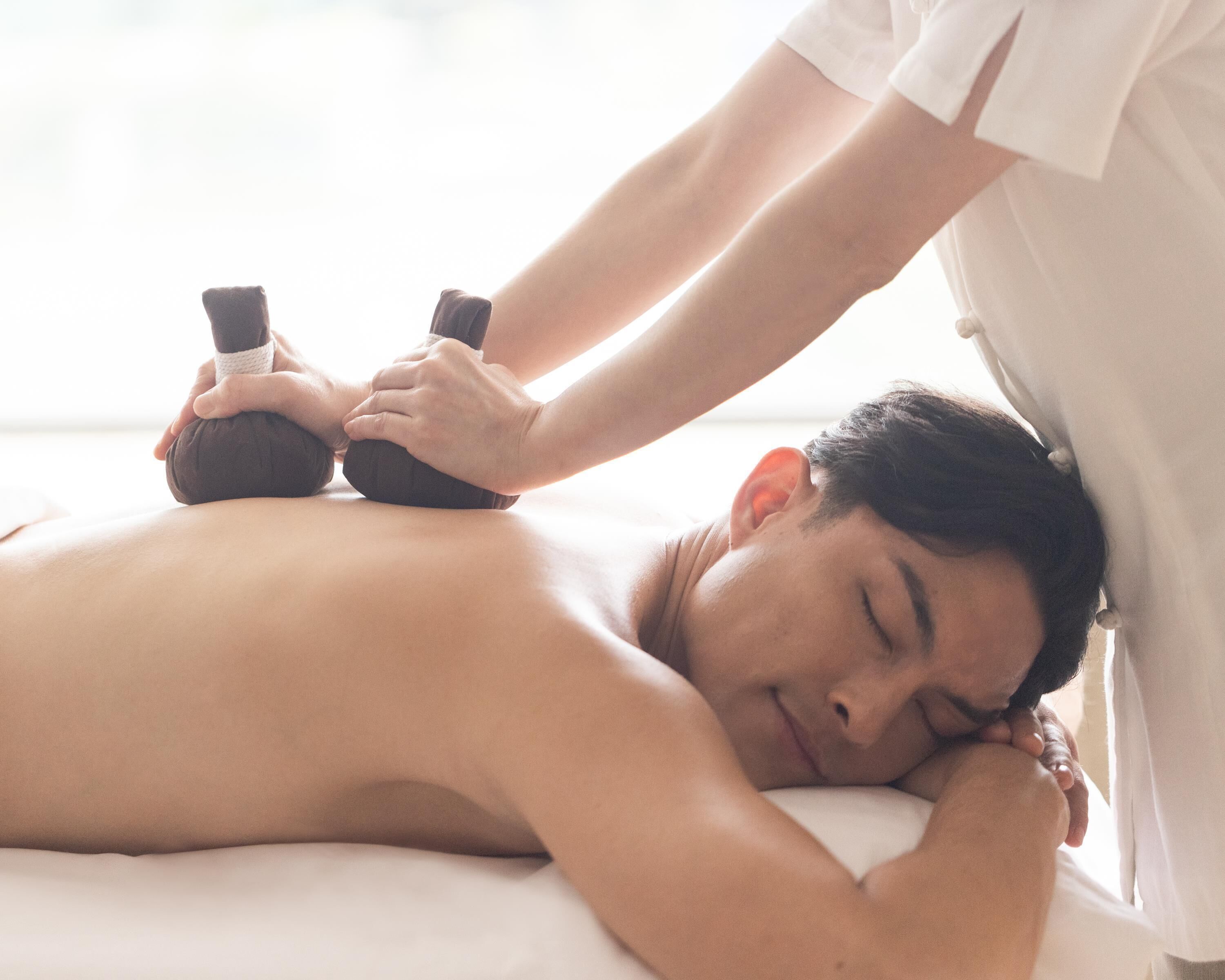 Uma pessoa recebendo massagem, com foco nas mãos e nos pés.