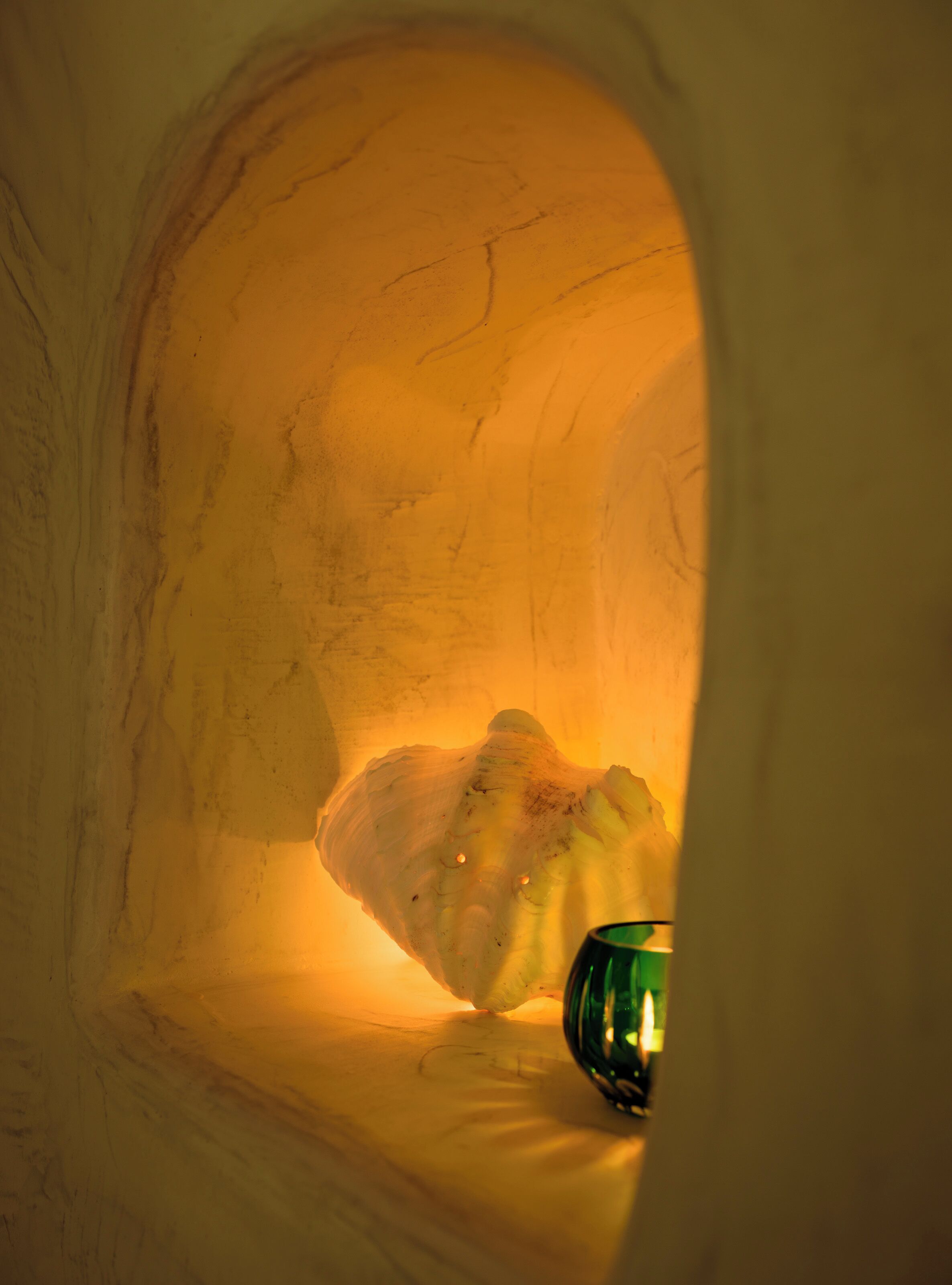 Interior de uma gruta de gelo com um objeto de vidro verde.